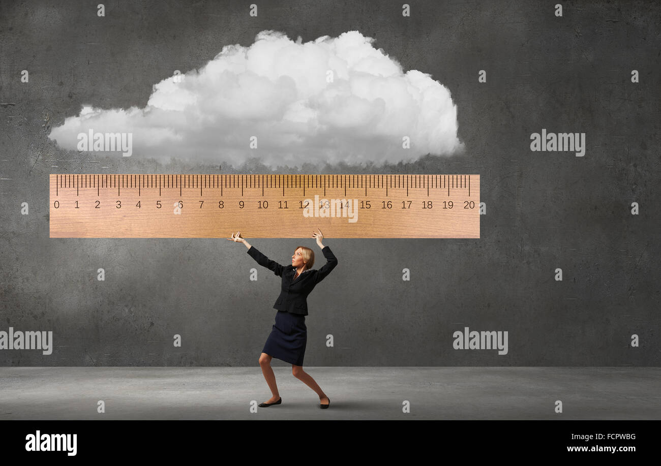 Young businesswoman measuring something with big ruler Stock Photo - Alamy