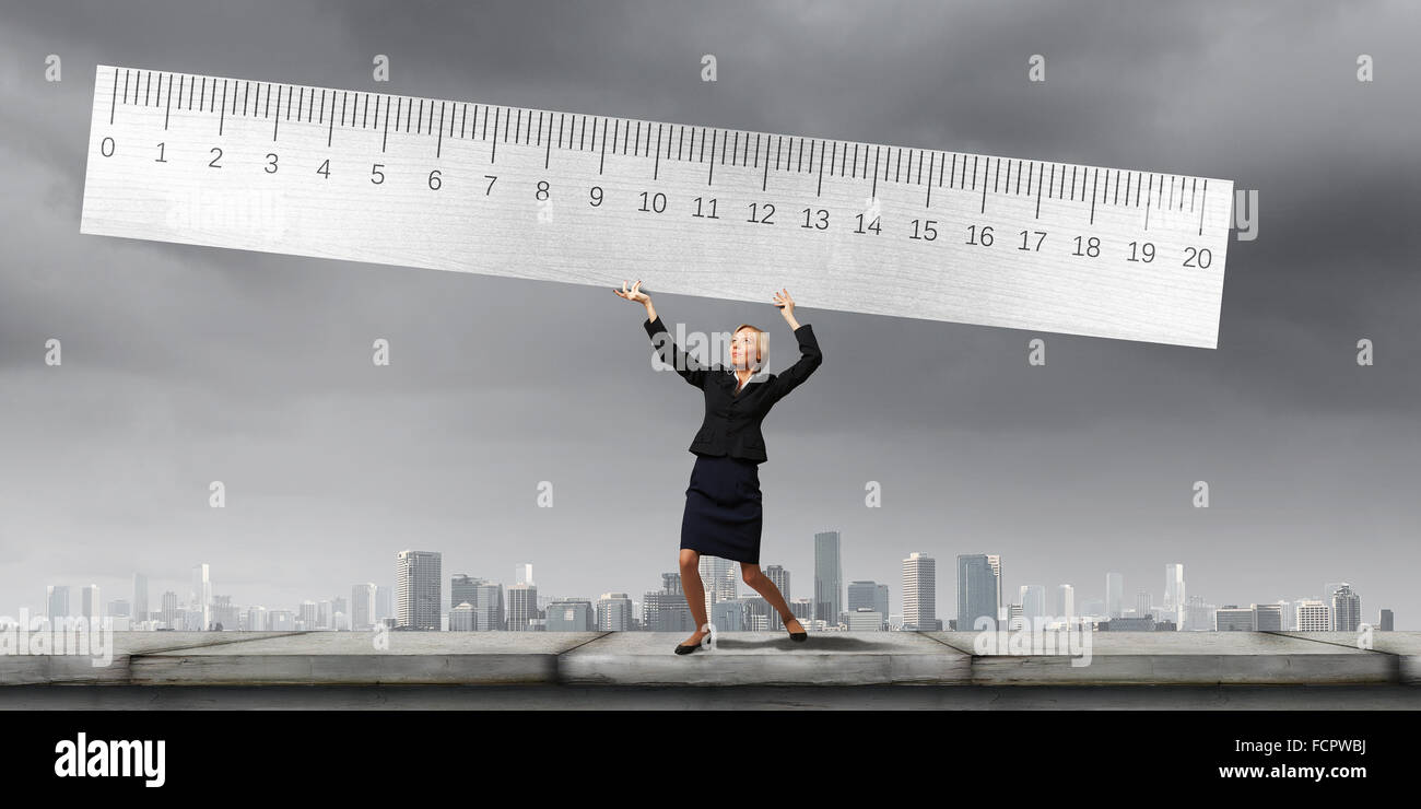 Young businesswoman measuring something with big ruler Stock Photo - Alamy