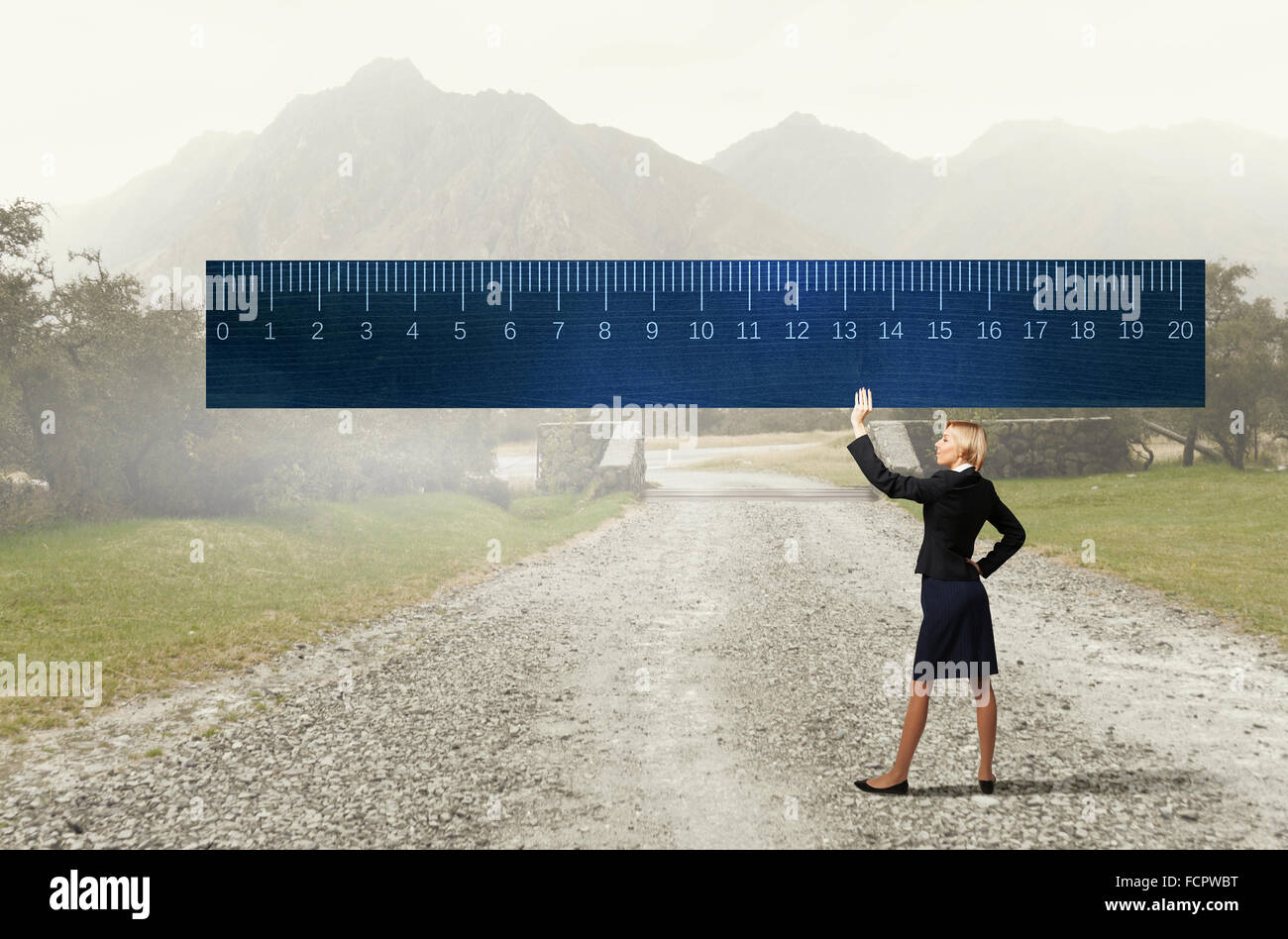 Young businesswoman measuring something with big ruler Stock Photo - Alamy