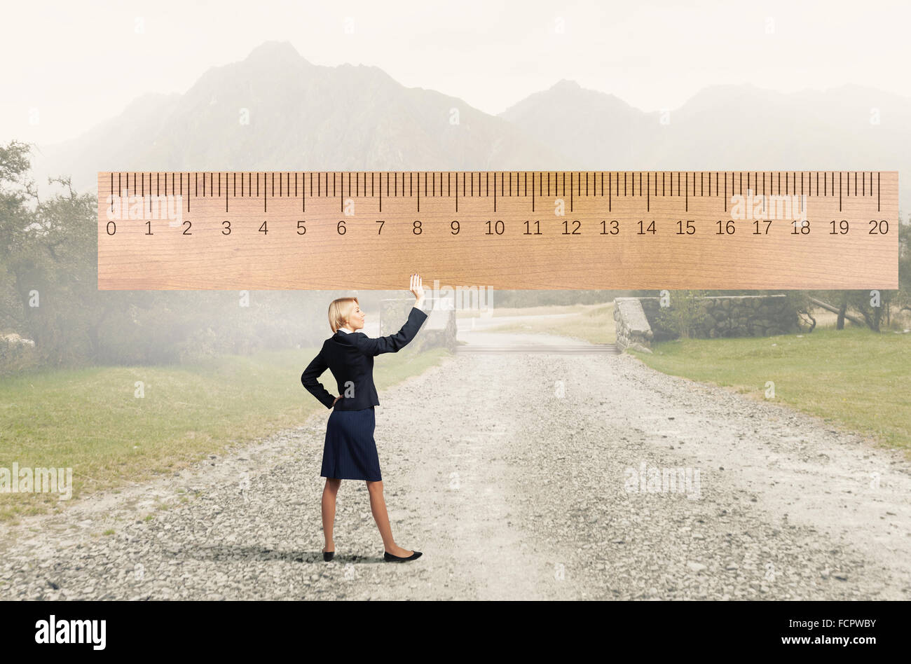Young businesswoman measuring something with big ruler Stock Photo - Alamy