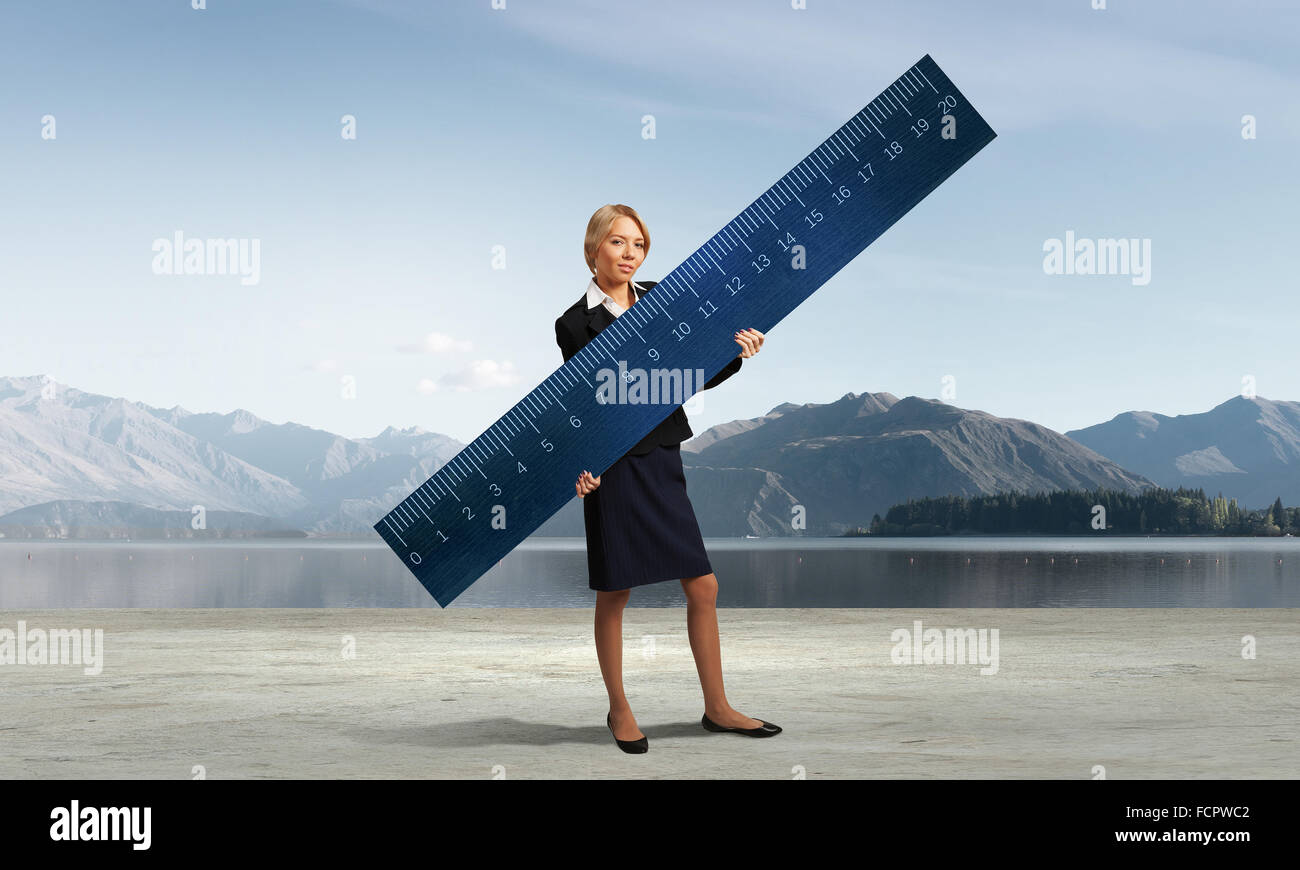 Young businesswoman measuring something with big ruler Stock Photo - Alamy