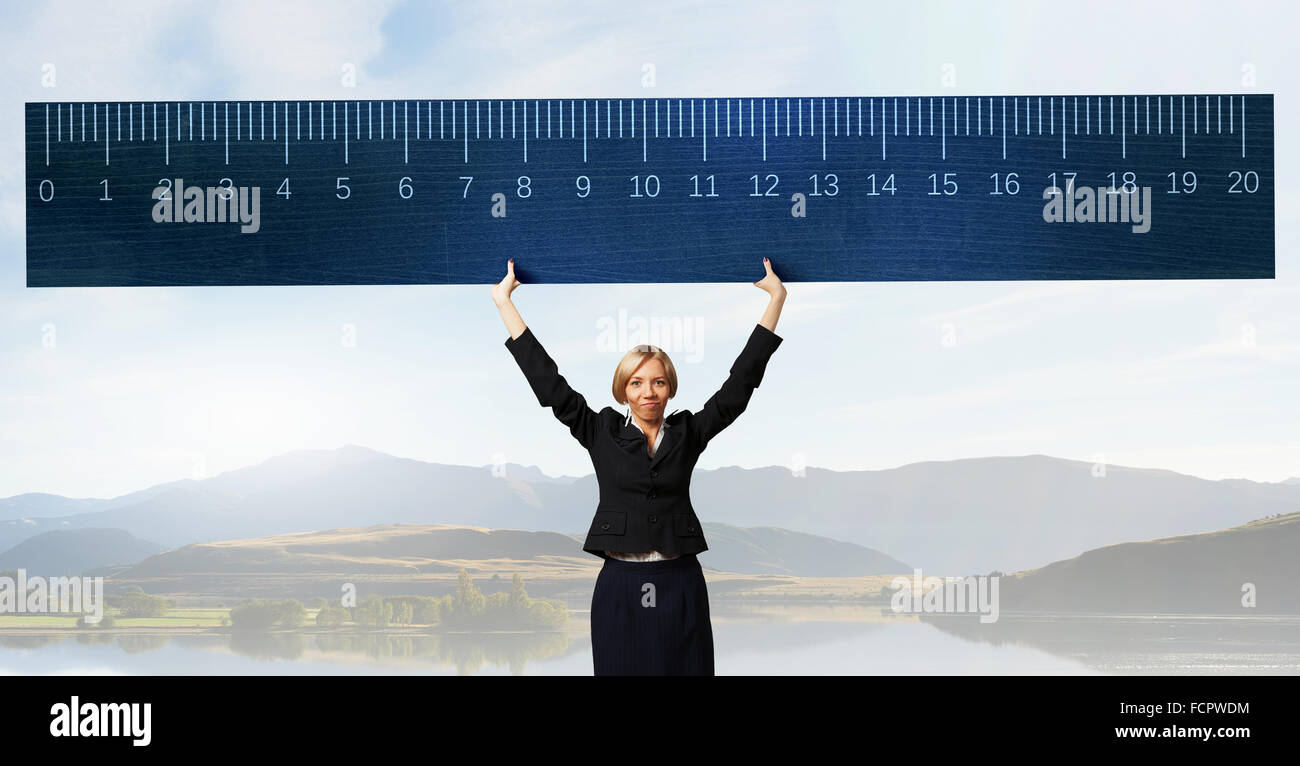 Young businesswoman measuring something with big ruler Stock Photo - Alamy