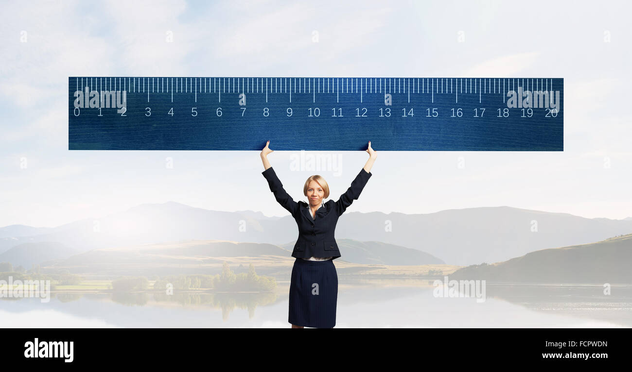 Young businesswoman measuring something with big ruler Stock Photo - Alamy