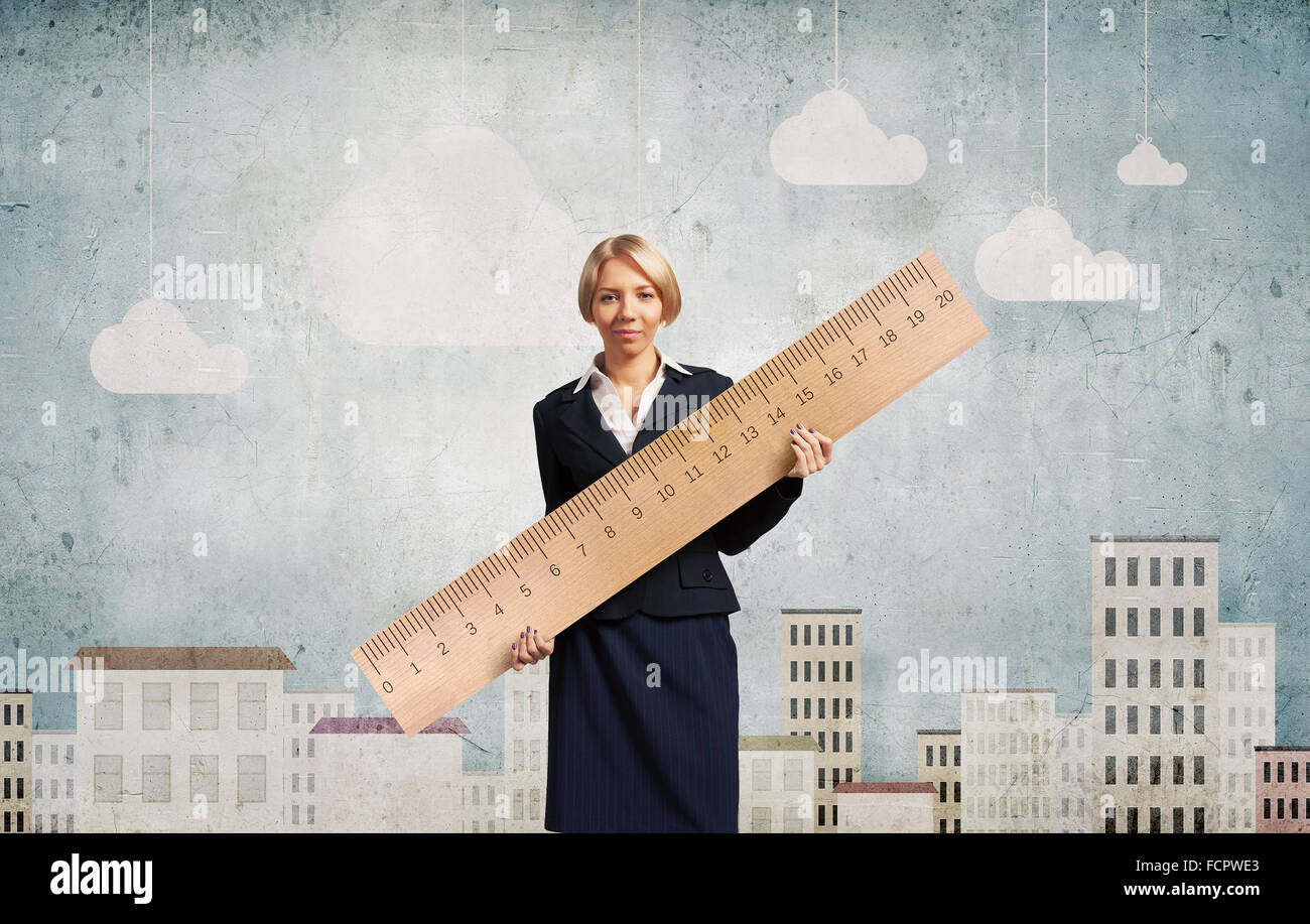 Young businesswoman measuring something with big ruler Stock Photo - Alamy