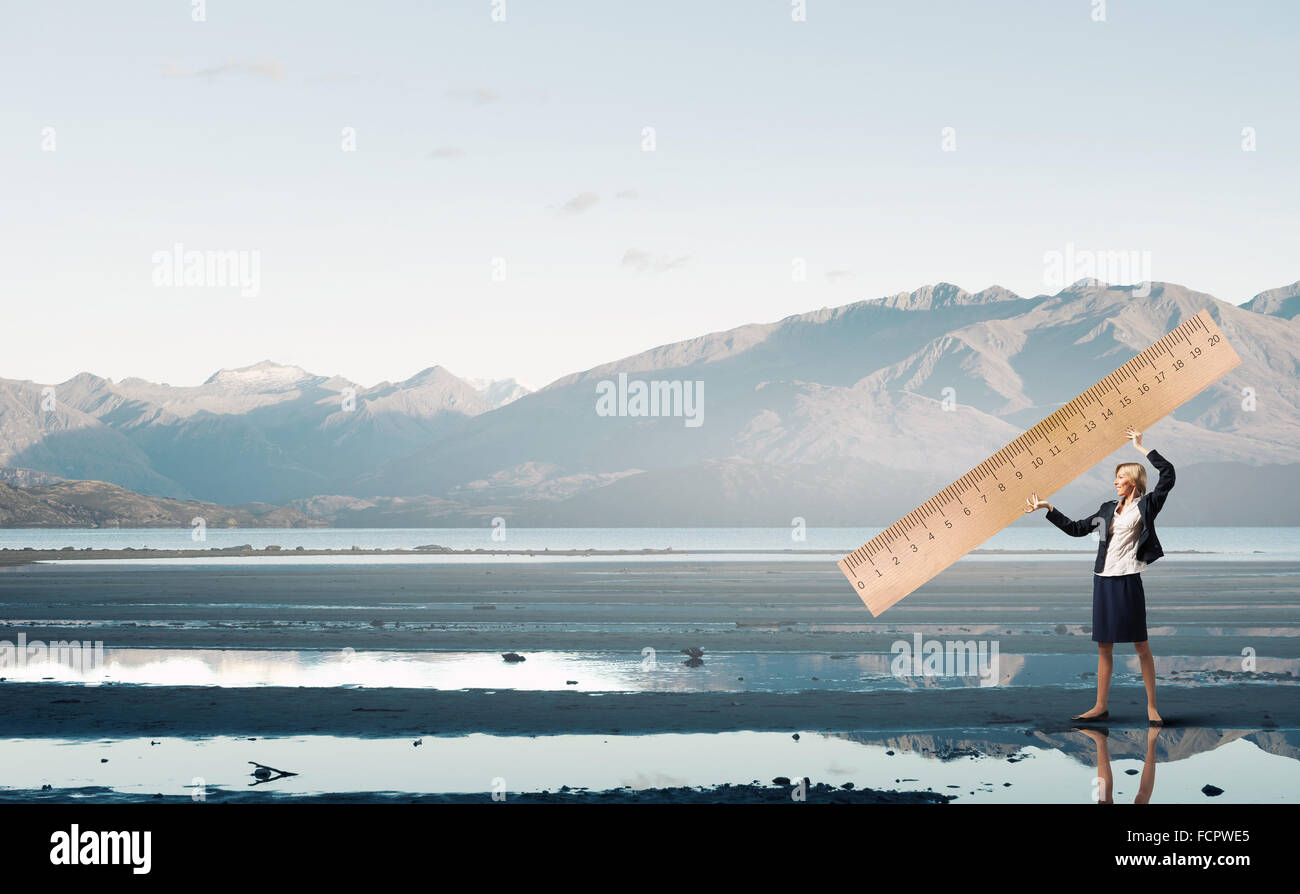 Young businesswoman measuring something with big ruler Stock Photo - Alamy