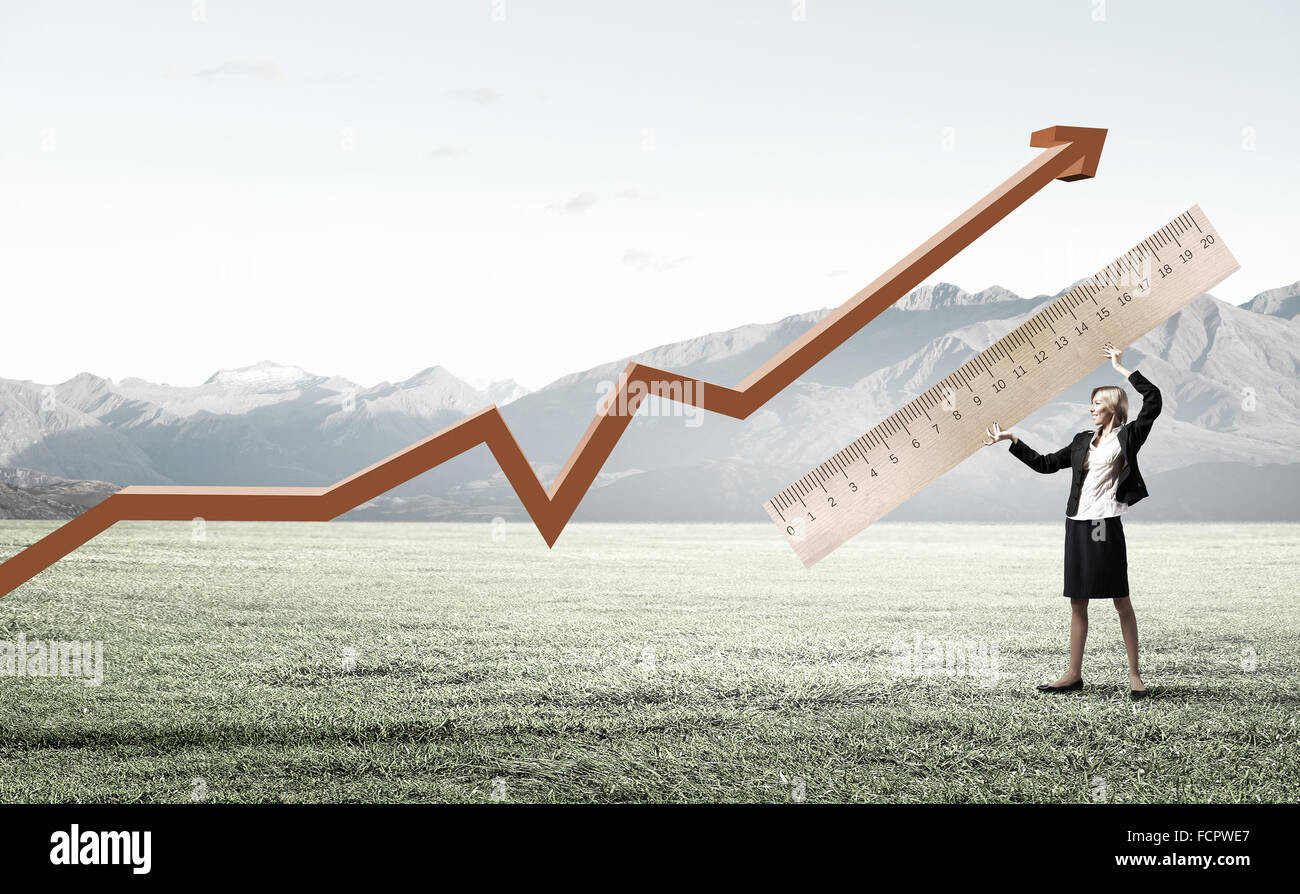 Young businesswoman measuring something with big ruler Stock Photo - Alamy