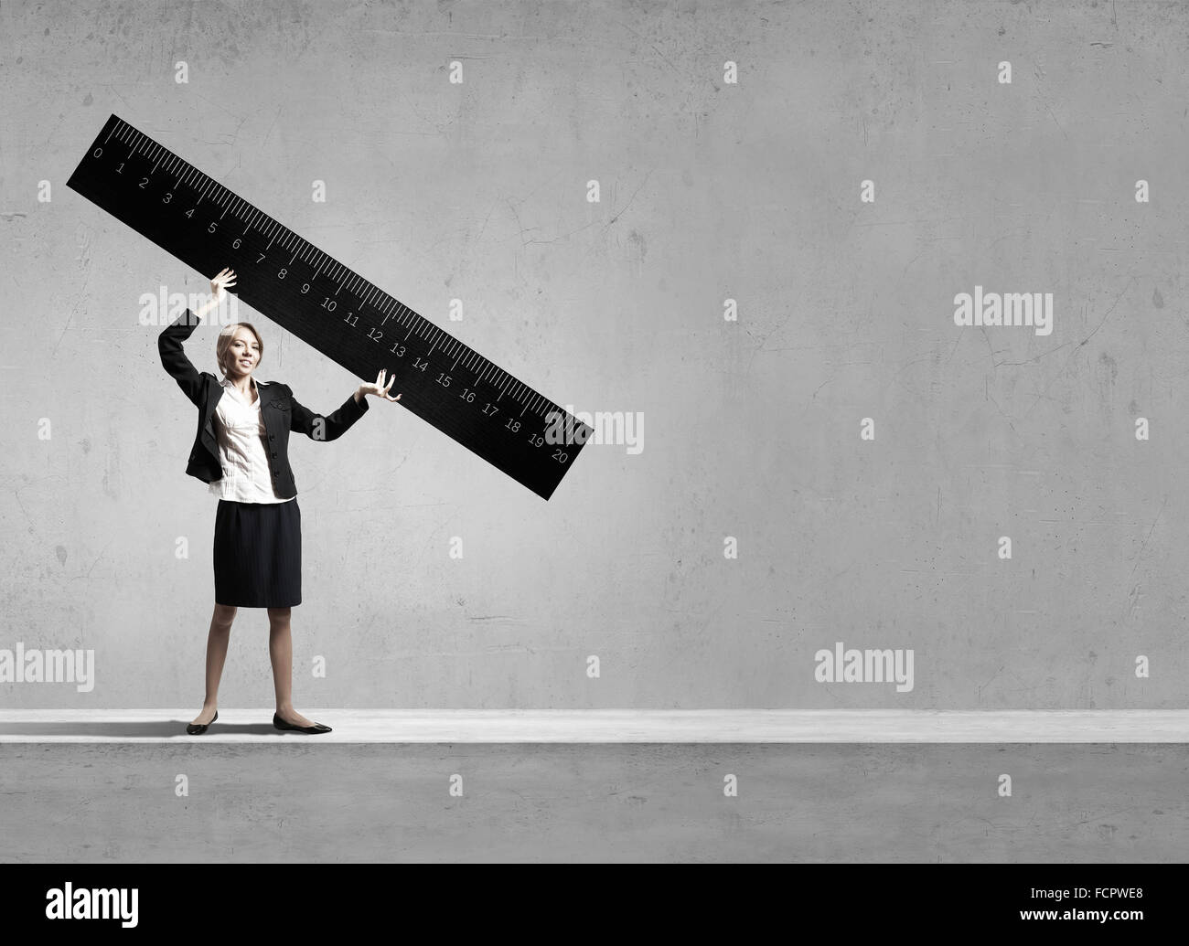 Young businesswoman measuring something with big ruler Stock Photo - Alamy