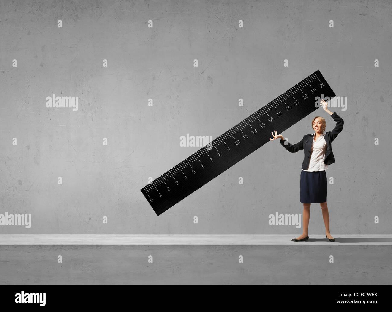 Young businesswoman measuring something with big ruler Stock Photo - Alamy