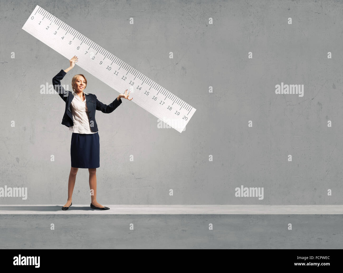 Young businesswoman measuring something with big ruler Stock Photo - Alamy