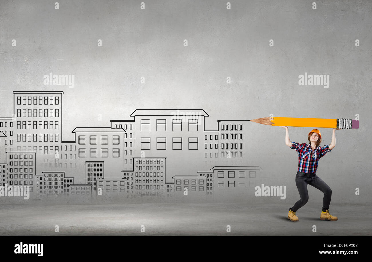 Young female engineer in hard hat with big pencil Stock Photo - Alamy