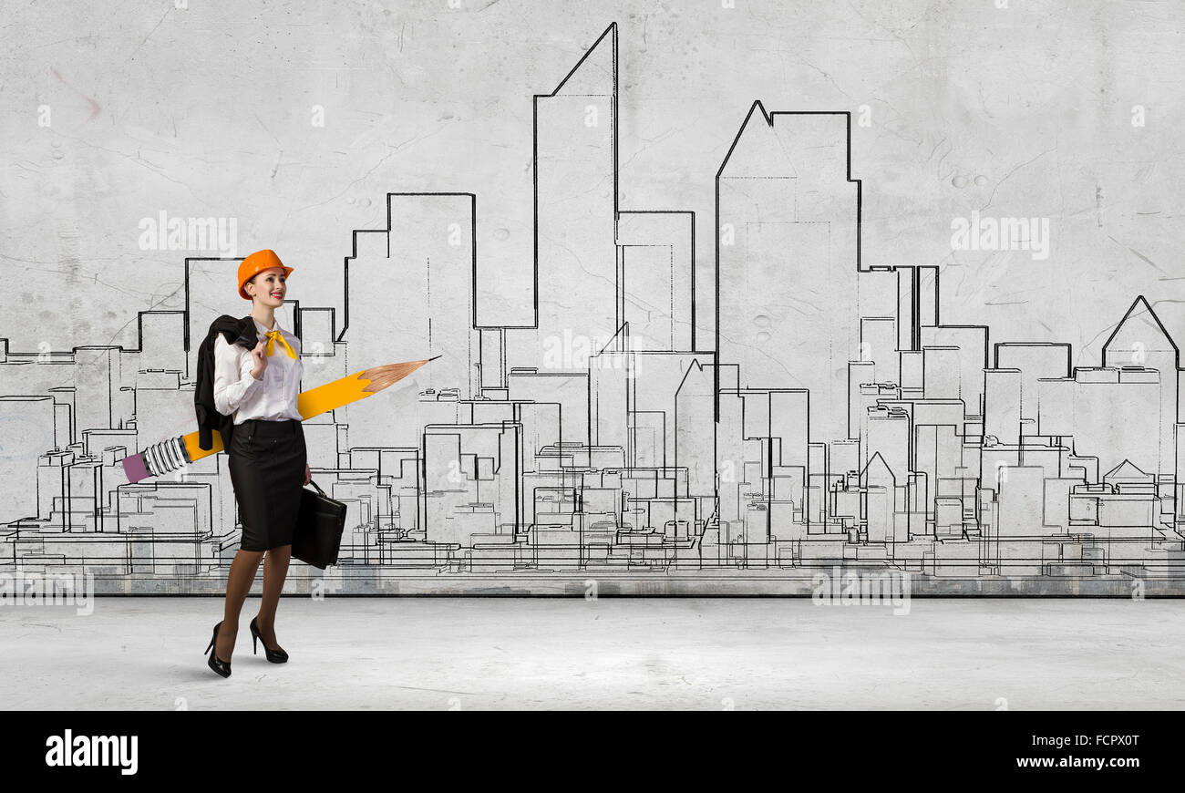 Young female engineer in hard hat with big pencil Stock Photo - Alamy