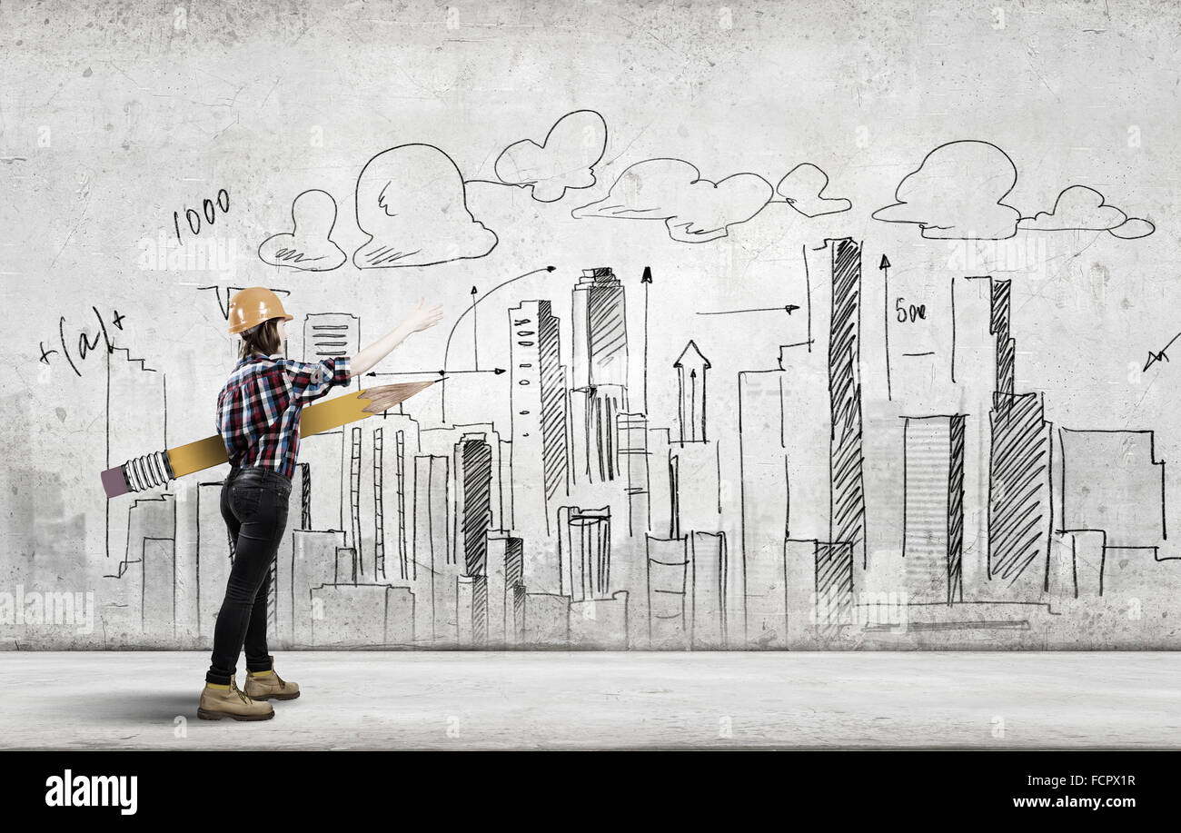 Young female engineer in hard hat with big pencil Stock Photo - Alamy