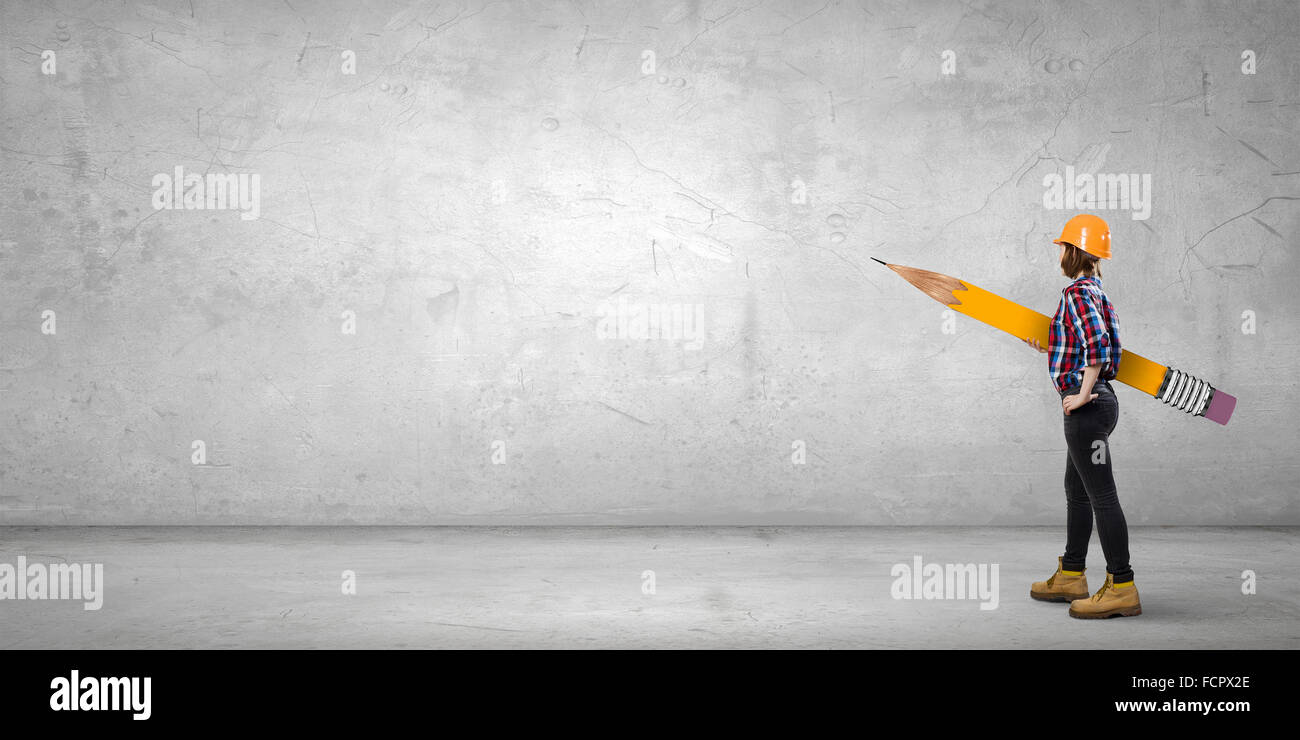 Young female engineer in hard hat with big pencil Stock Photo - Alamy