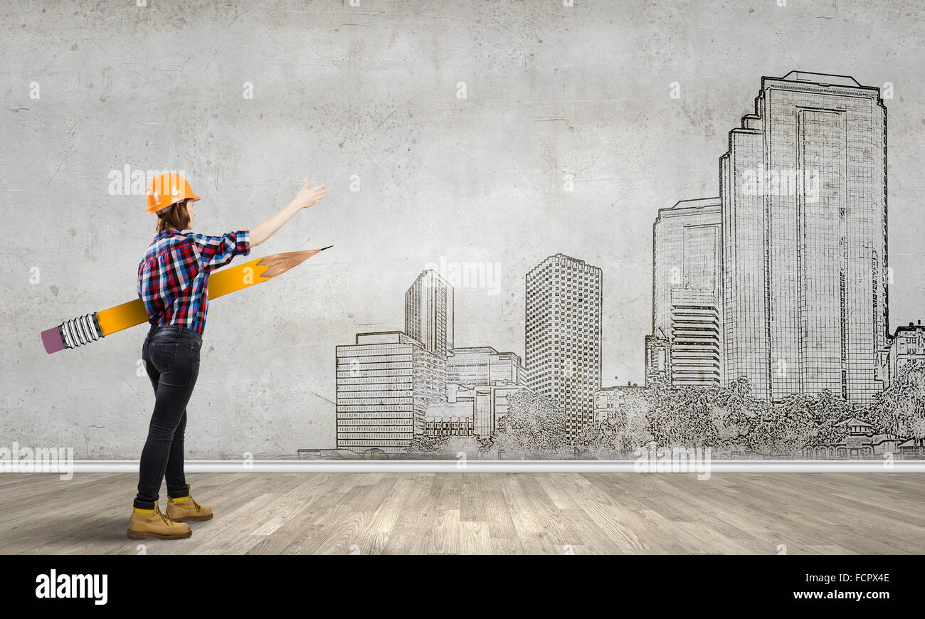 Young female engineer in hard hat with big pencil Stock Photo - Alamy