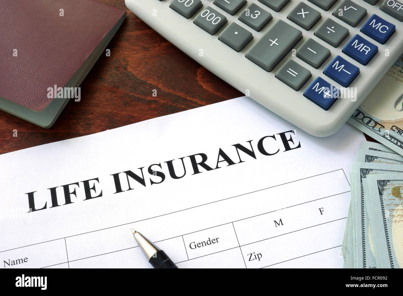 Life insurance form and dollars on the table Stock Photo - Alamy