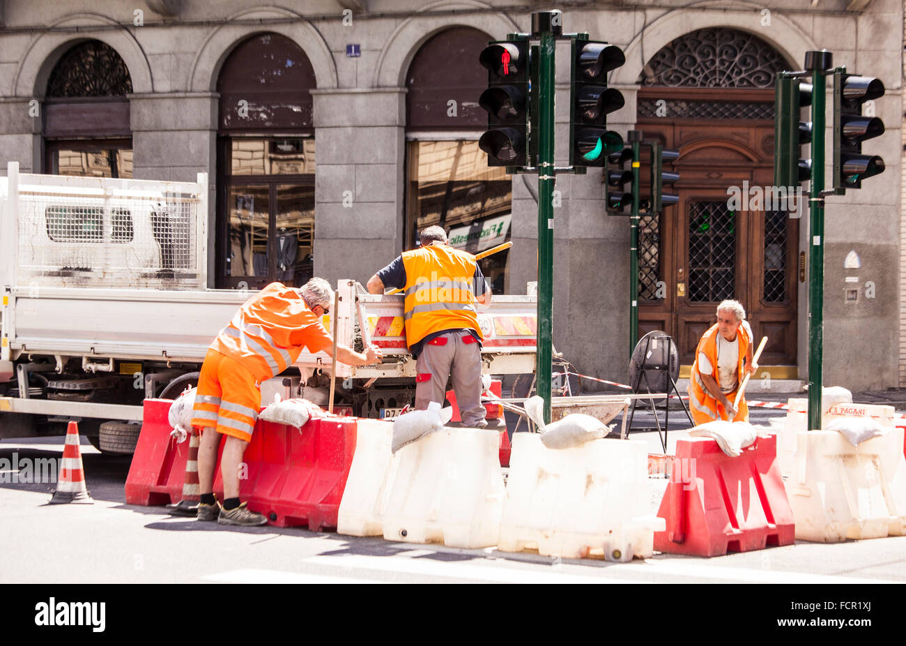 Men at work in the middle of an intersection of a city Stock Photo - Alamy