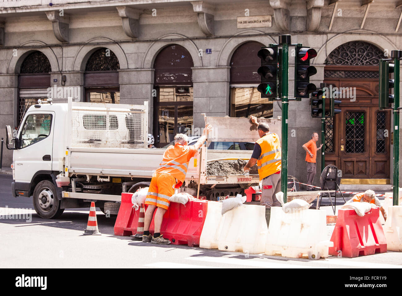 Men at work in the middle of an intersection of a city Stock Photo - Alamy