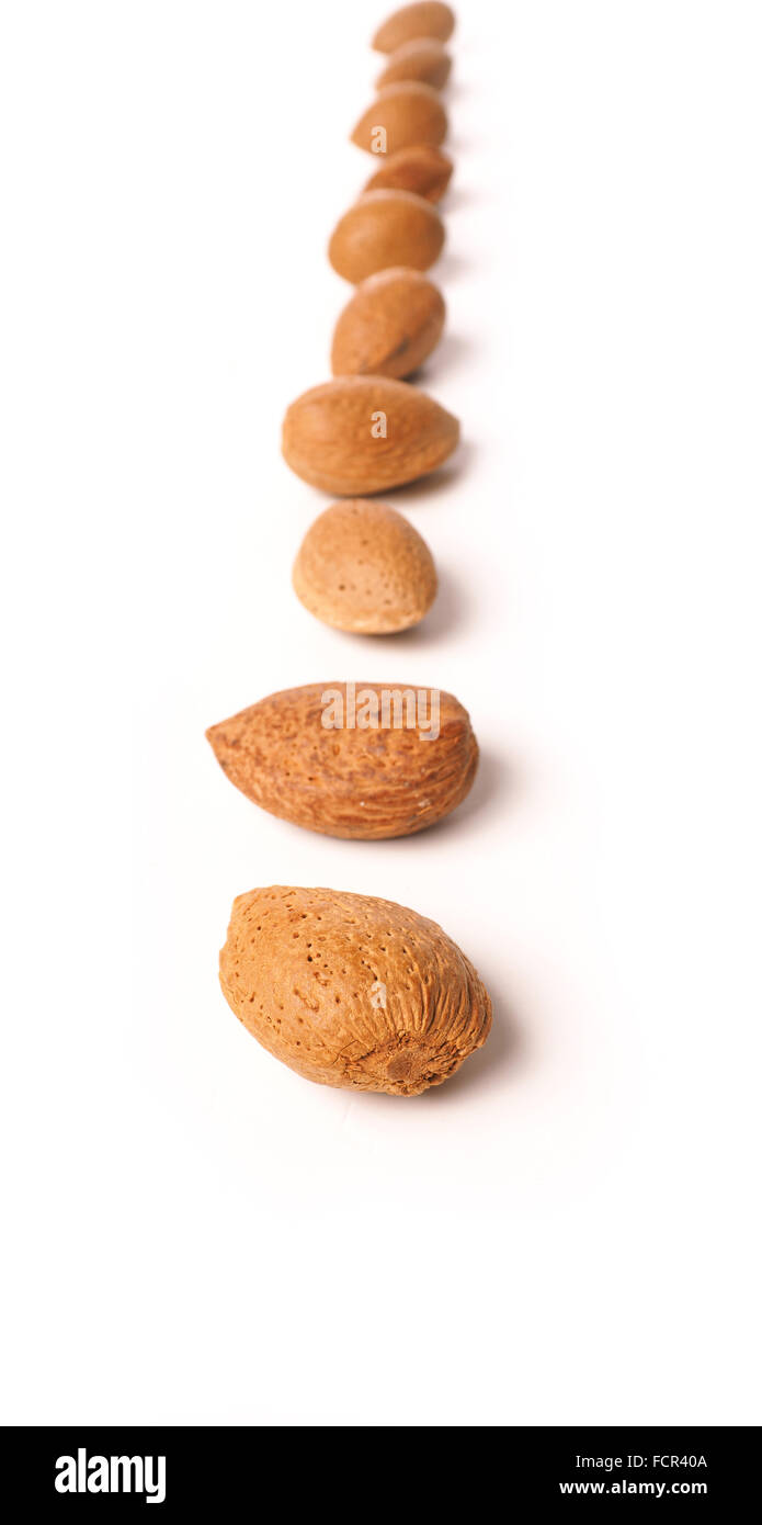 Almonds in a row on a white kitchen table Stock Photo - Alamy
