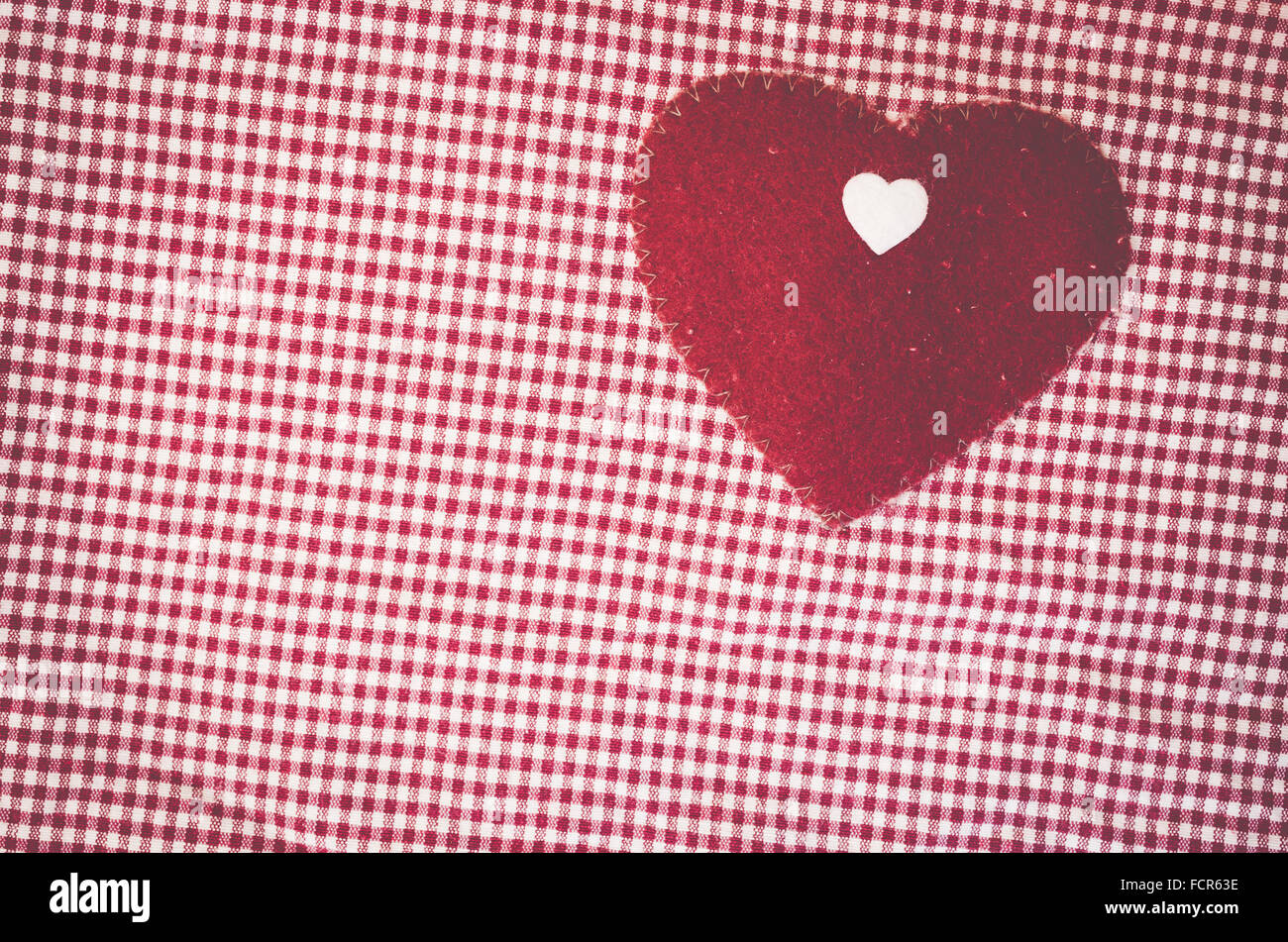 checkered cotton fabric and heart felt decoration on a wood background ...
