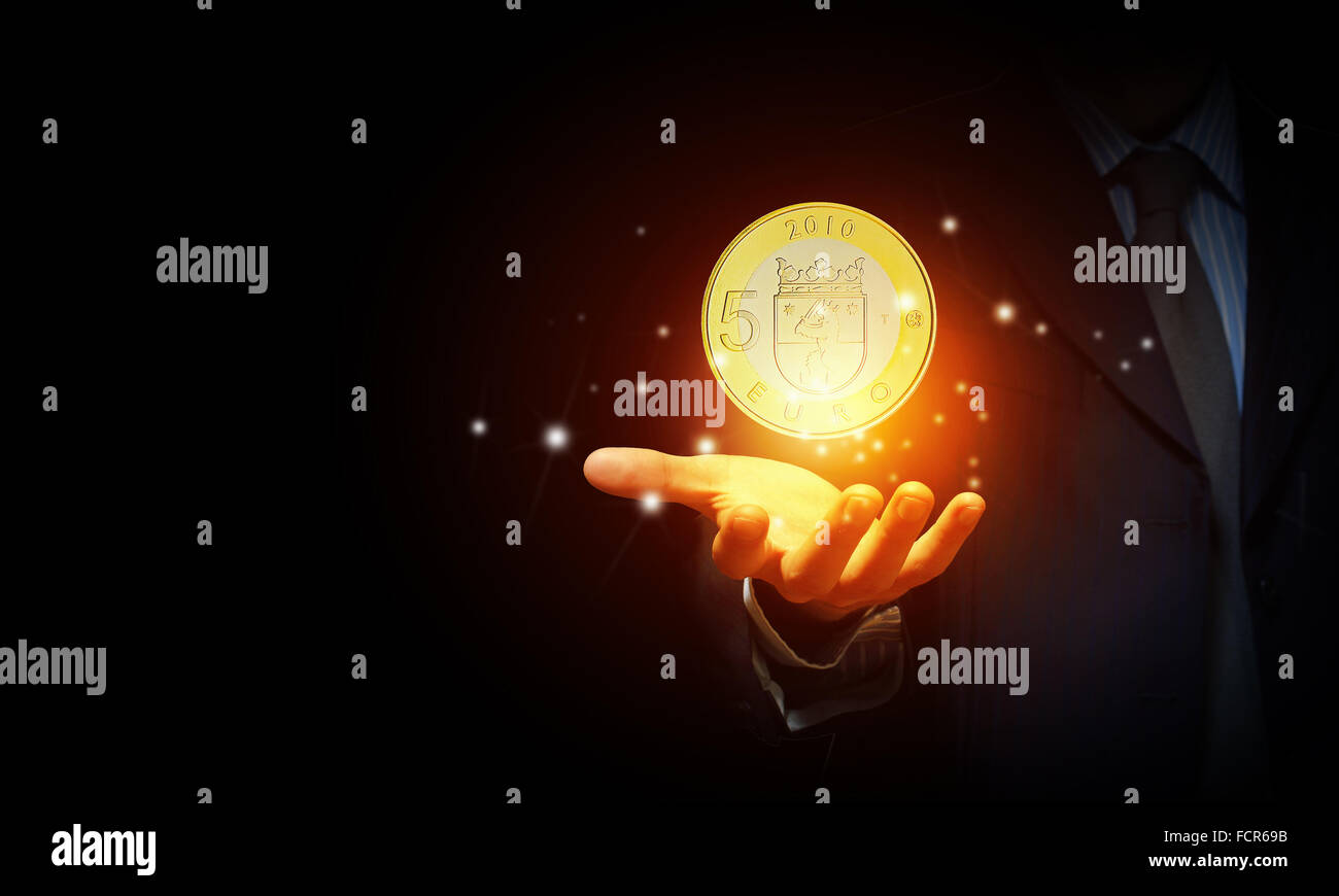 Close up of human hand holding golden euro coin Stock Photo - Alamy