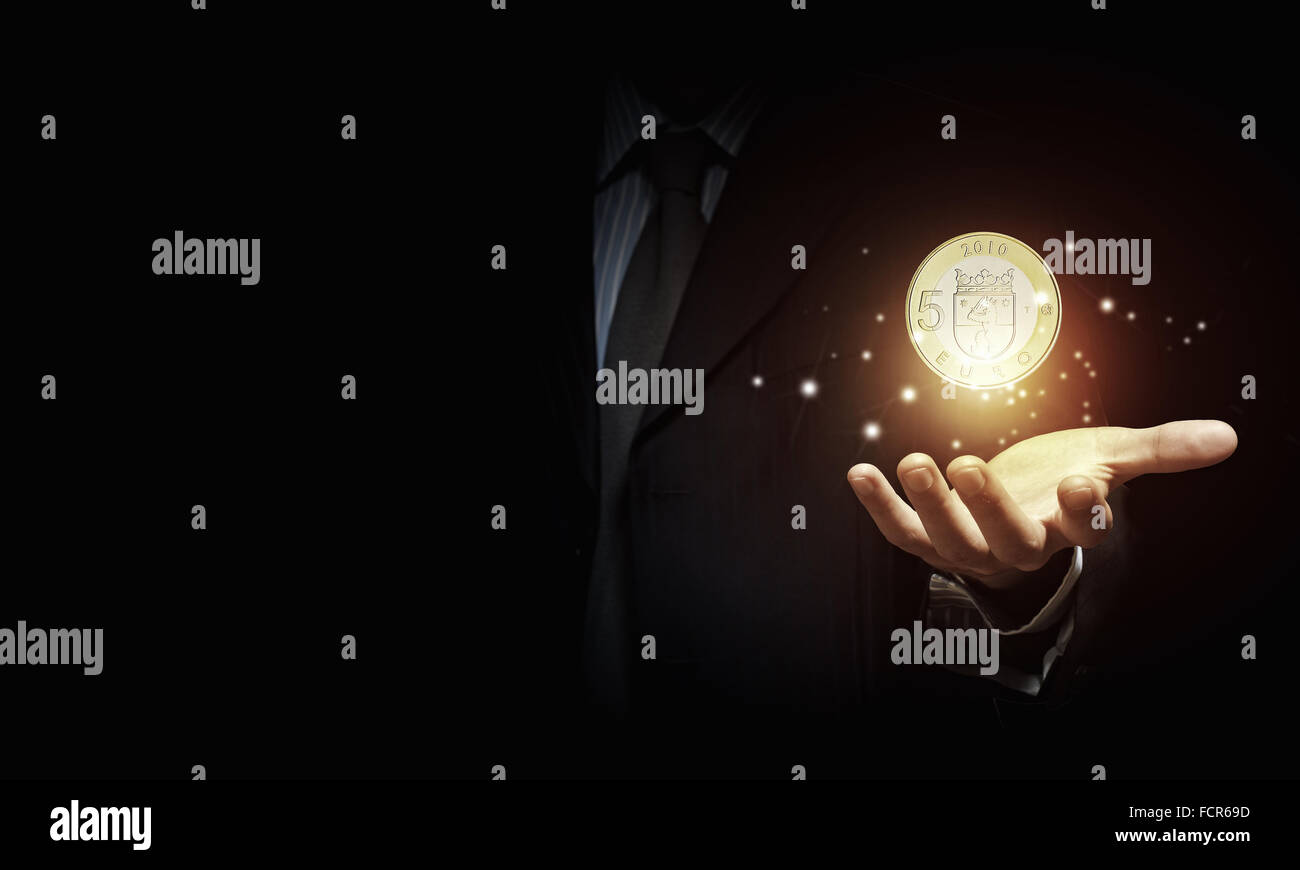 Close up of human hand holding golden euro coin Stock Photo - Alamy