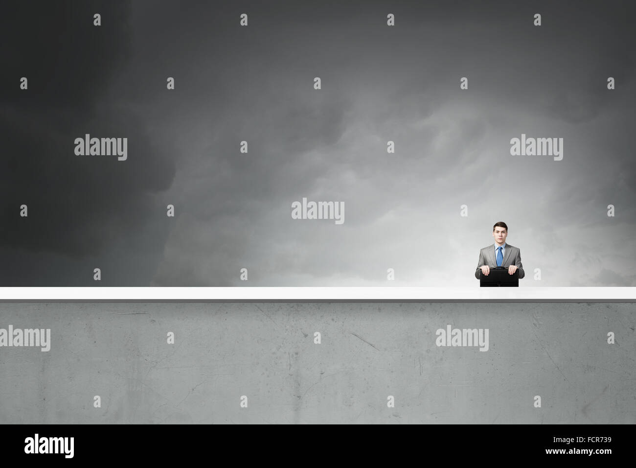 Young smiling businessman sitting with briefcase in hands Stock Photo ...