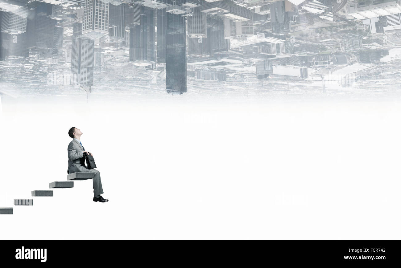 Young smiling businessman sitting with briefcase in hands Stock Photo ...