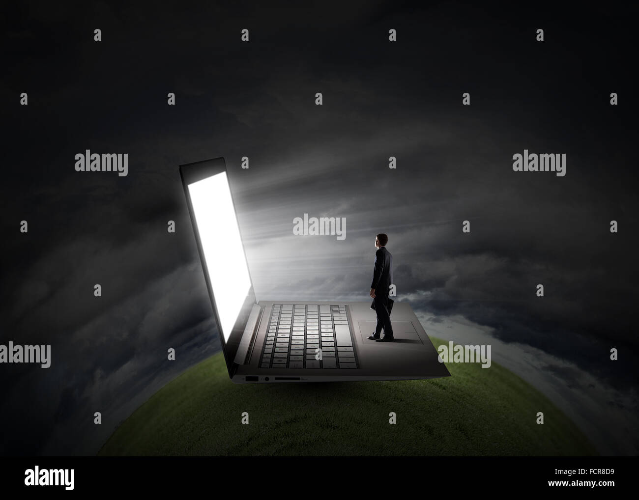 Young businessman with briefcase standing on huge laptop Stock Photo ...