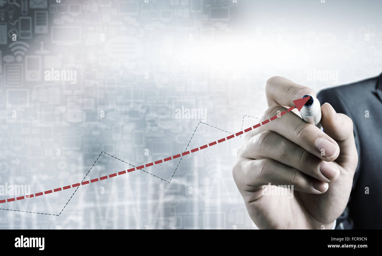 Close up of businessman drawing increasing graph with marker on media ...