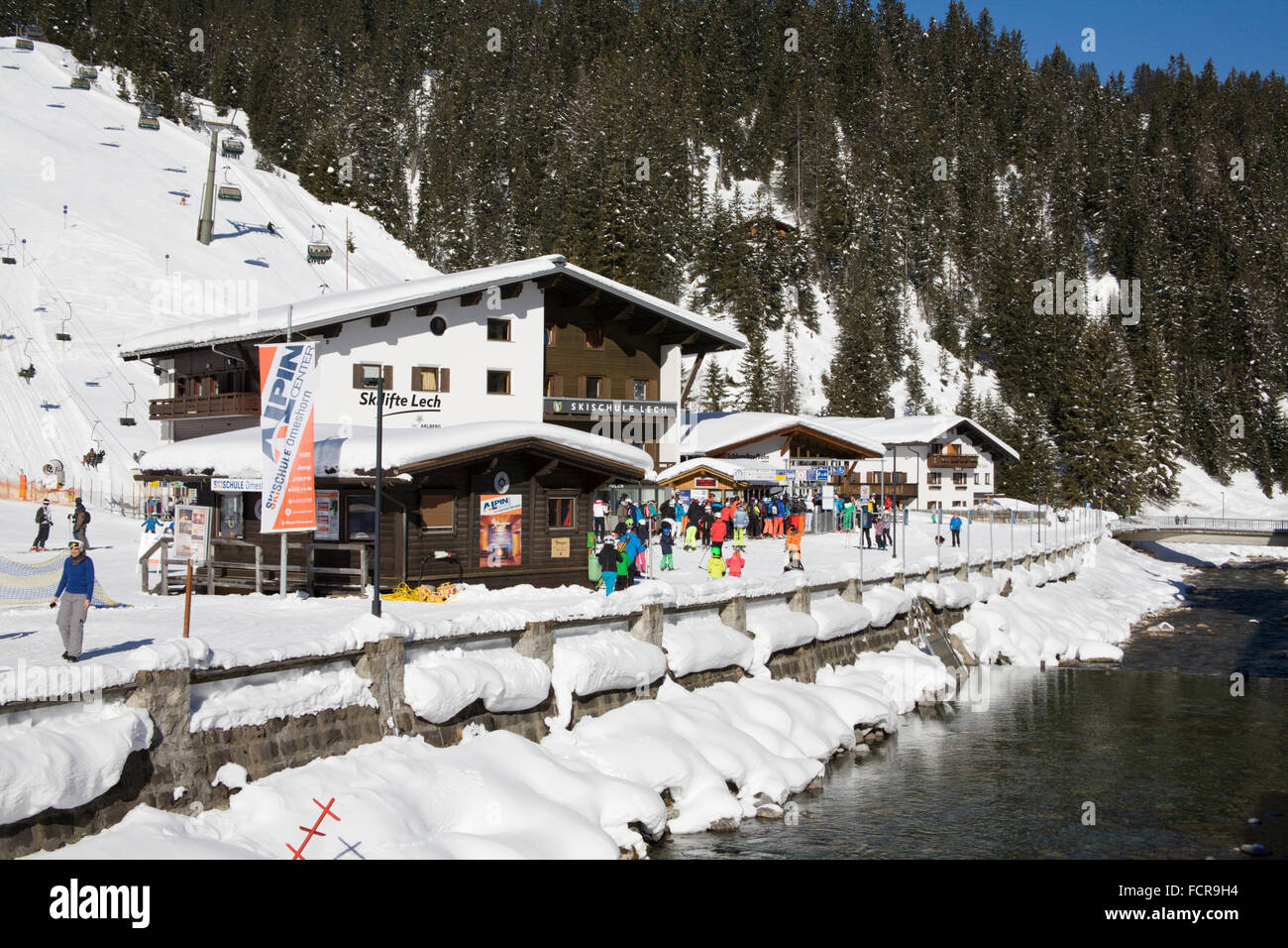 The River Lech flowing through Lech with beside ski schools and pistes ...