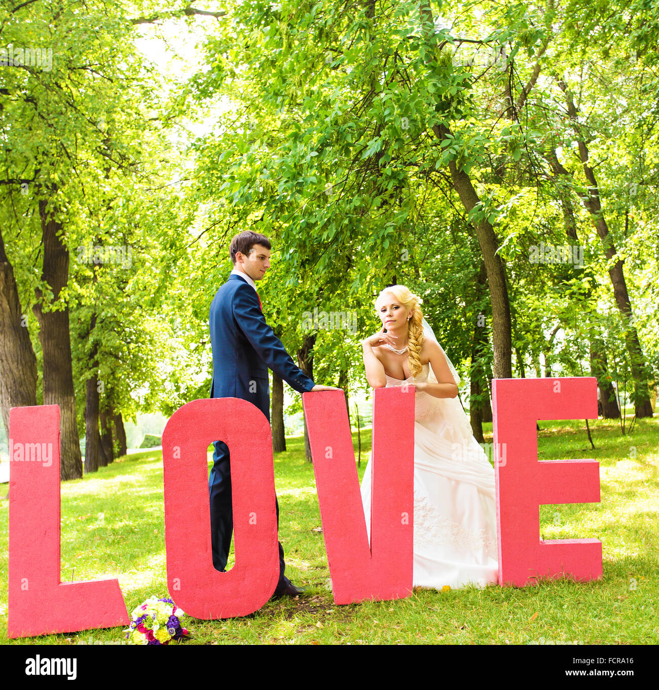 Happy bride and groom with letter the word love Stock Photo - Alamy