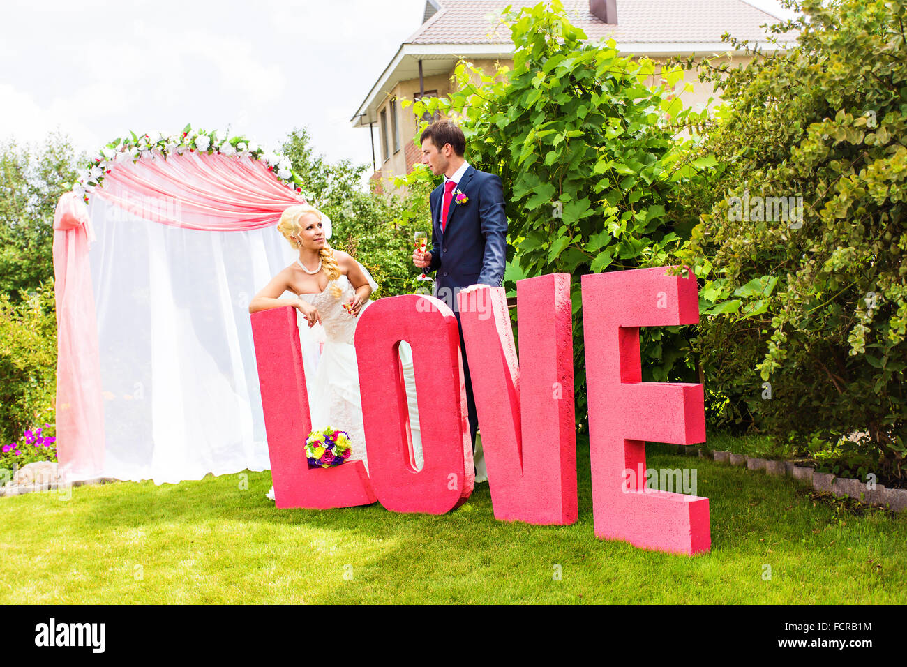 Happy bride and groom with letter the word love Stock Photo - Alamy