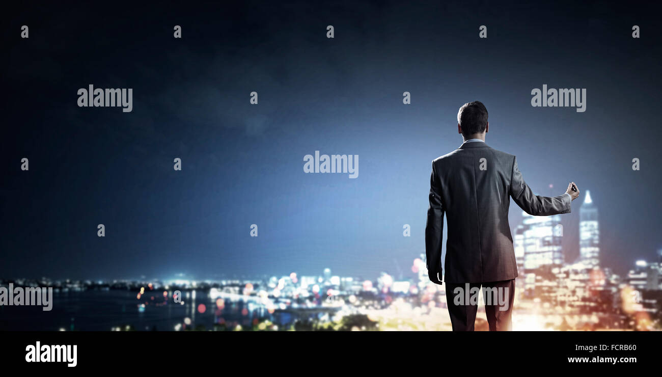 Rear view of businessman looking at night city Stock Photo - Alamy