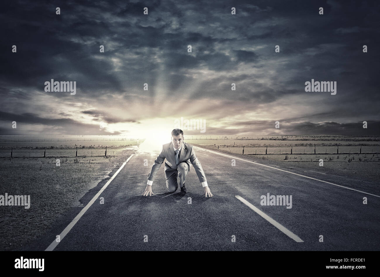 Young determined businessman standing in start position Stock Photo - Alamy