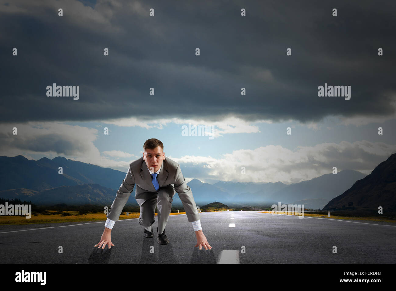 Young determined businessman standing in start position Stock Photo - Alamy
