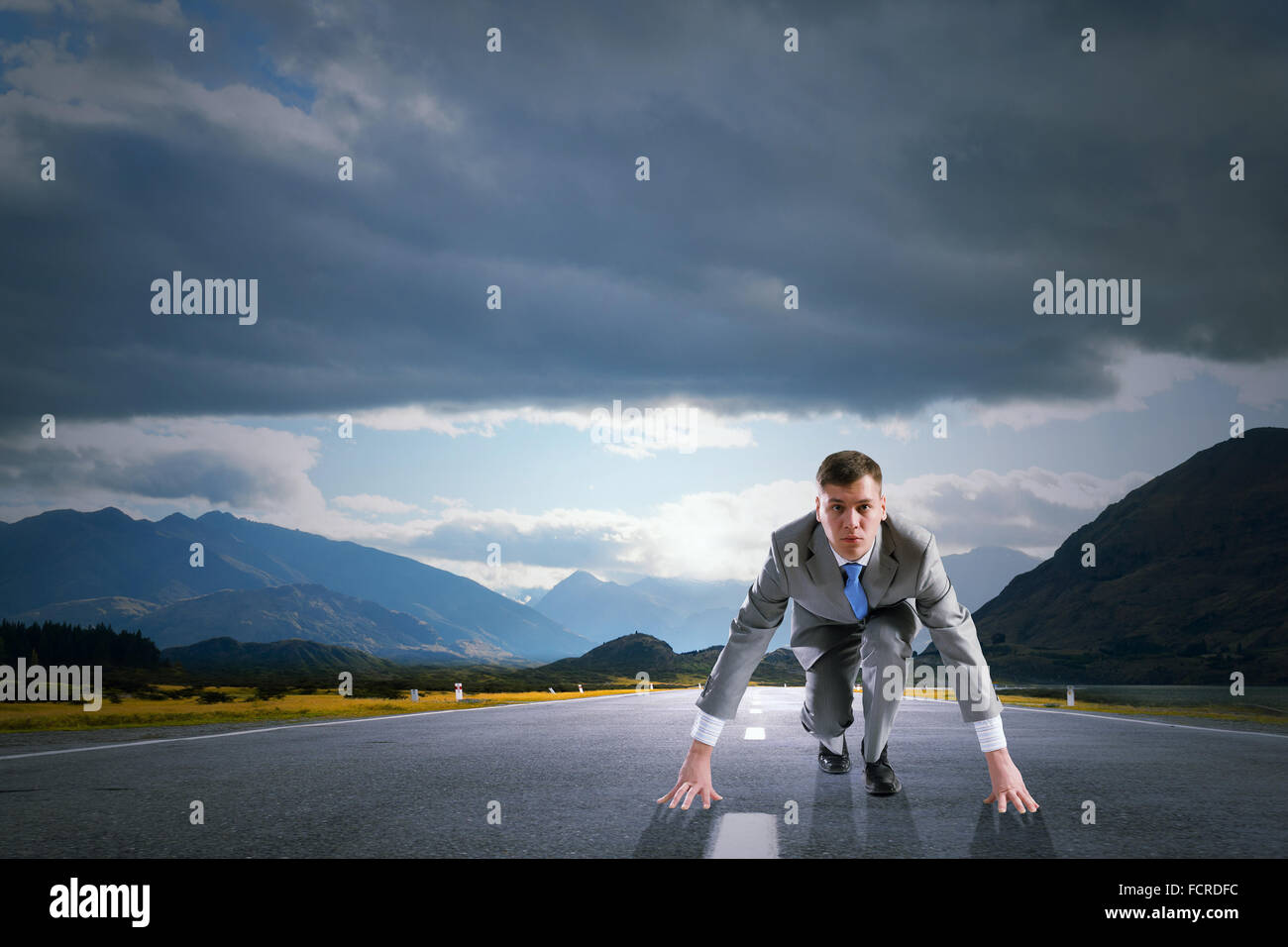 Young determined businessman standing in start position Stock Photo - Alamy