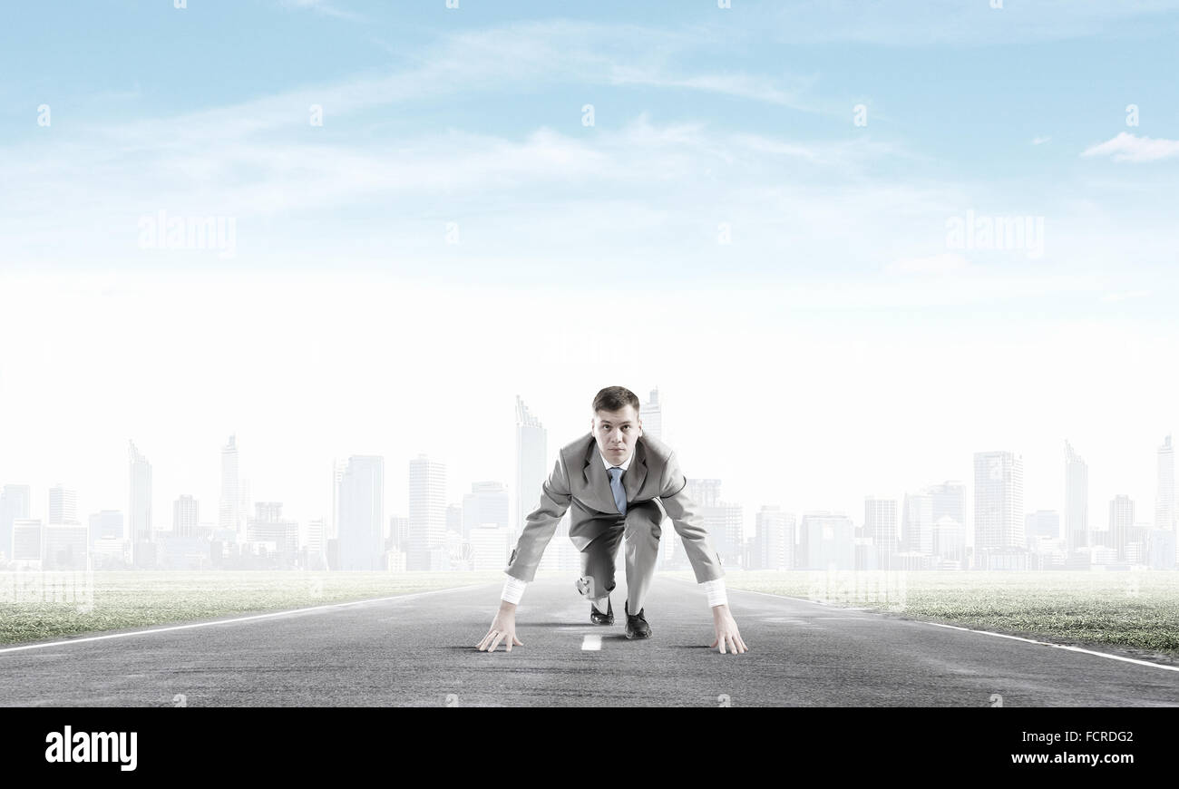 Young determined businessman standing in start position Stock Photo - Alamy