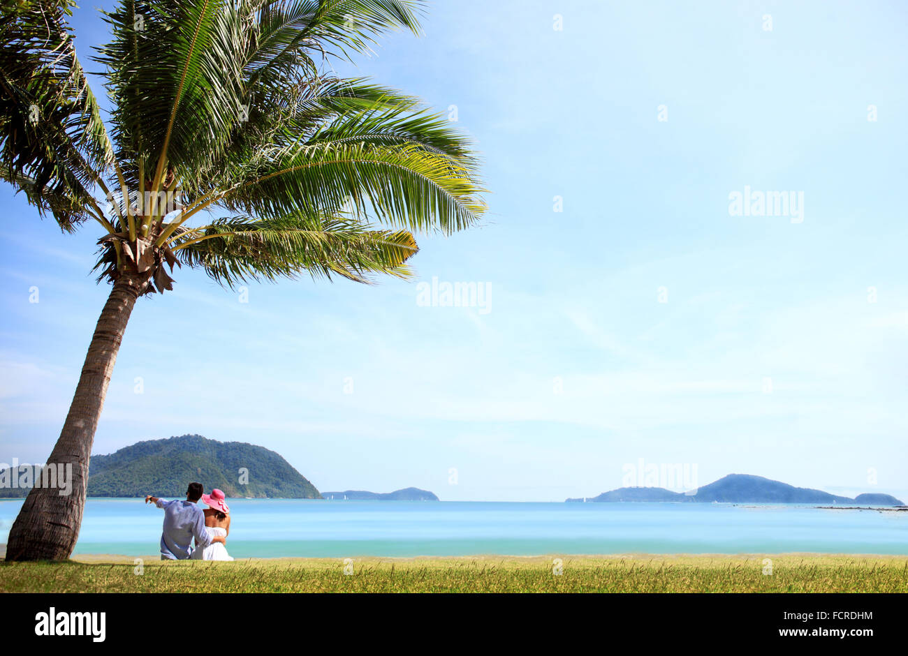Man sitting under palm tree hi-res stock photography and images - Alamy