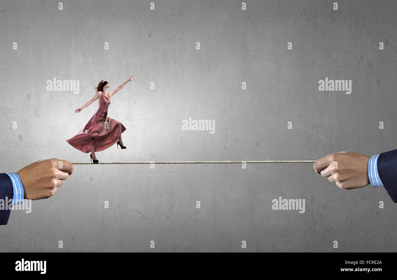 Woman in evening dress and blindfold walking on rope Stock Photo - Alamy