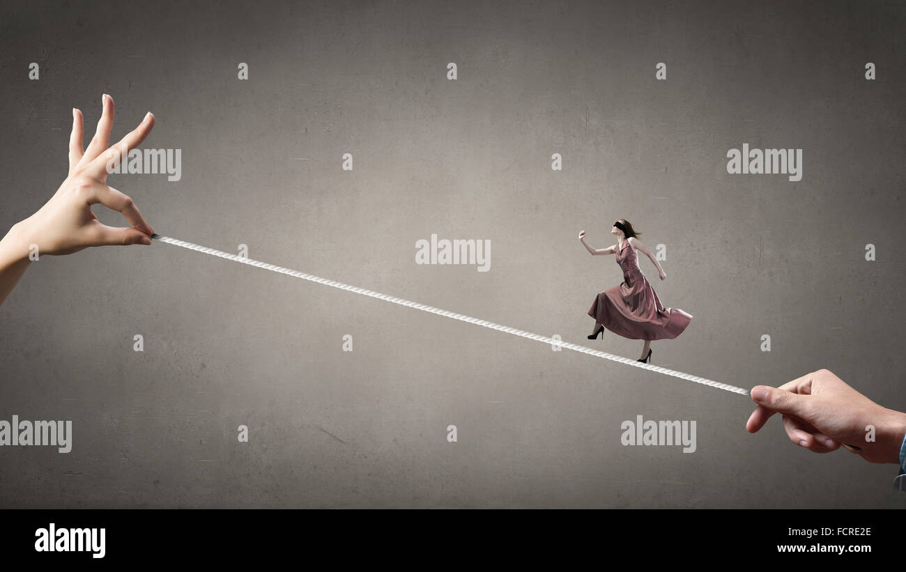 Woman in evening dress and blindfold walking on rope Stock Photo - Alamy
