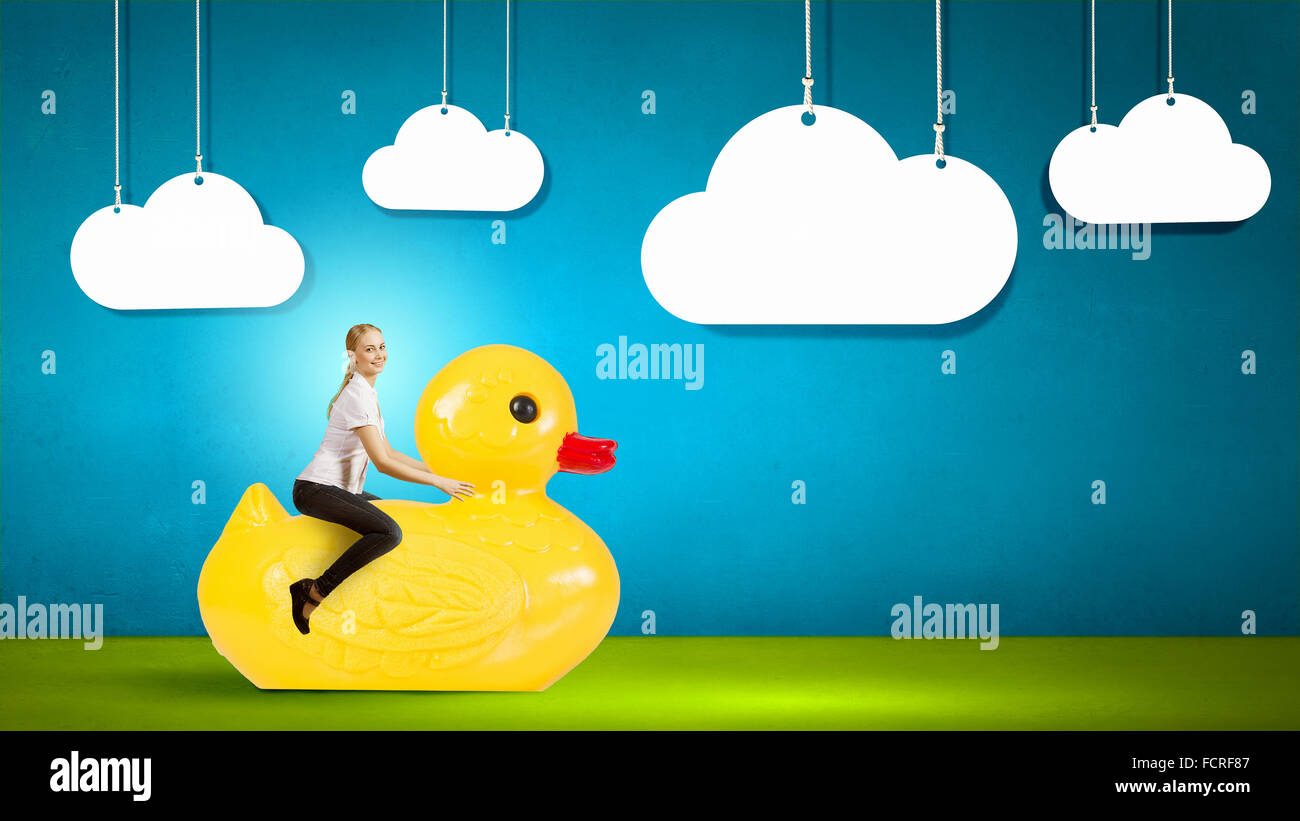Young happy businesswoman riding yellow rubber duck Stock Photo - Alamy