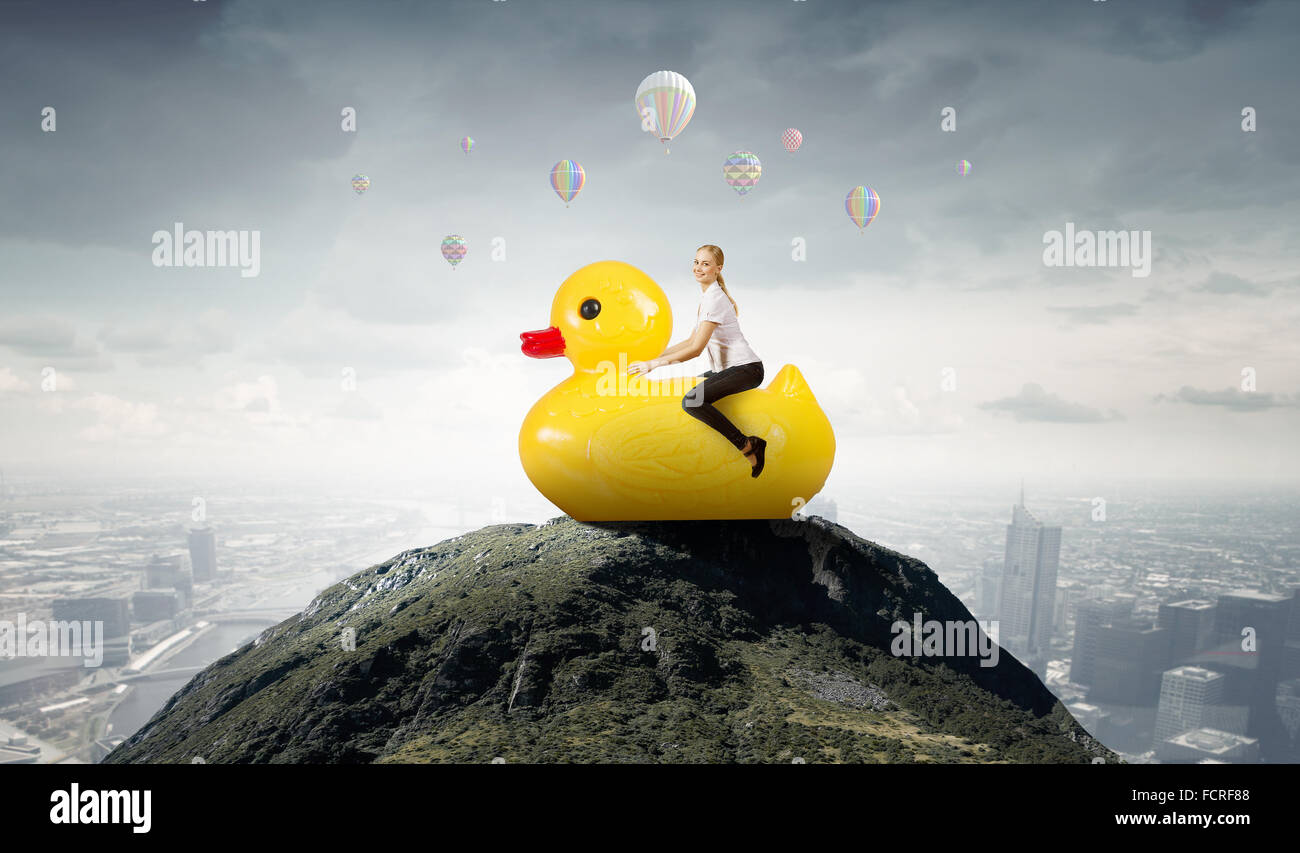 Young happy businesswoman riding yellow rubber duck Stock Photo - Alamy