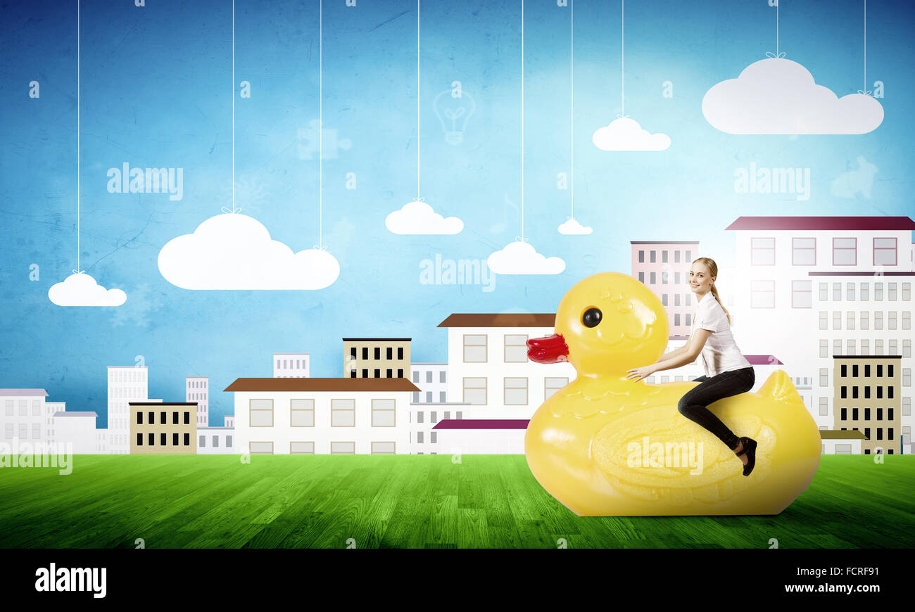 Young happy businesswoman riding yellow rubber duck Stock Photo - Alamy