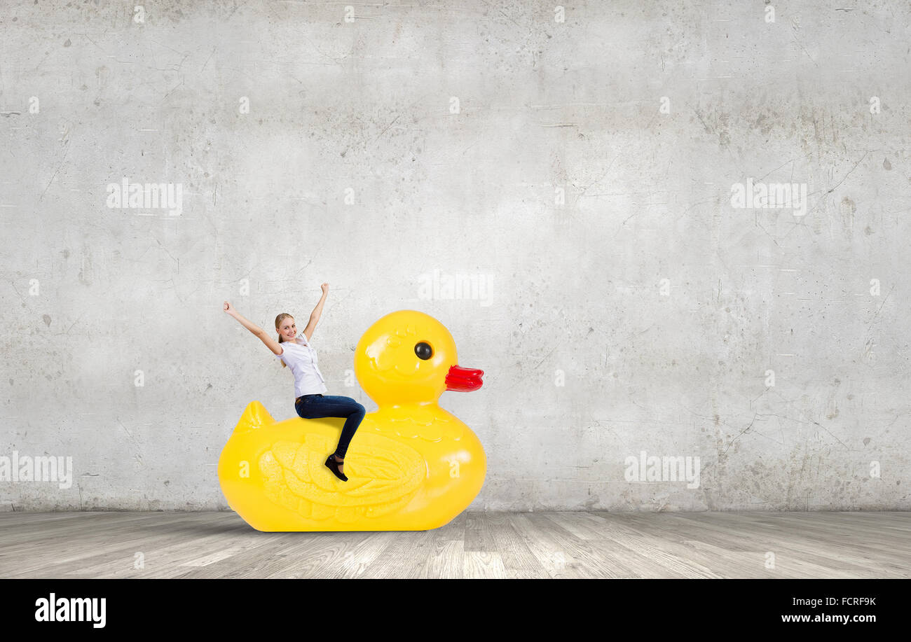 Young happy businesswoman riding yellow rubber duck Stock Photo - Alamy