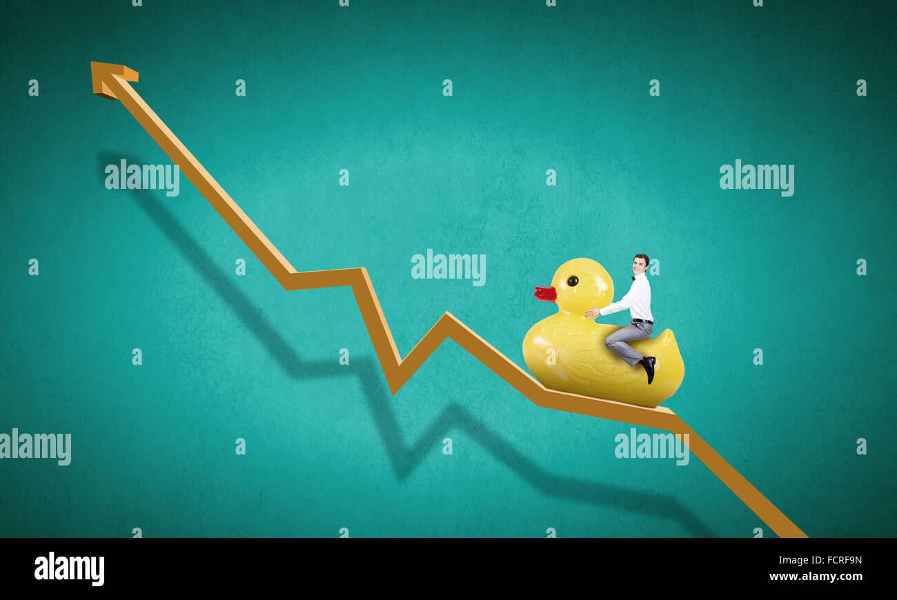 Young happy businessman riding yellow rubber duck Stock Photo - Alamy