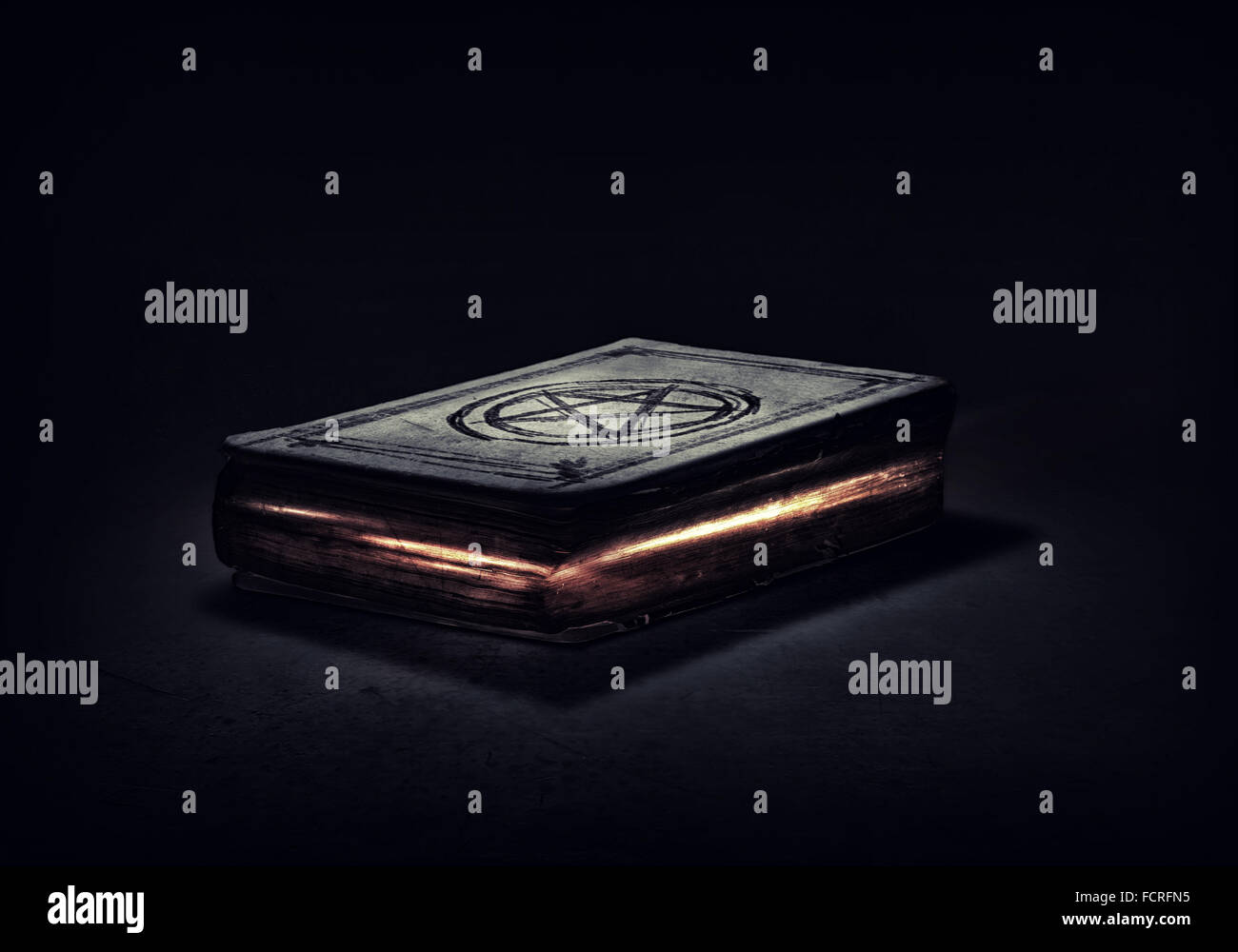 Old black magic book with lights on pages Stock Photo - Alamy