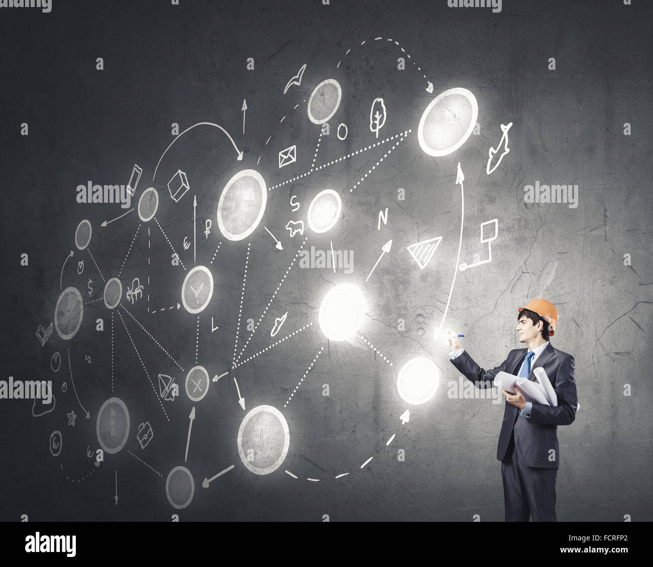 Young man engineer in helmet drawing connection lines Stock Photo - Alamy