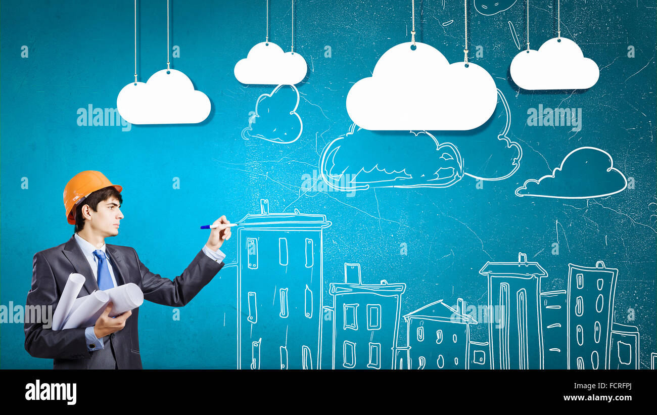 Young man engineer in helmet drawing construction project Stock Photo ...