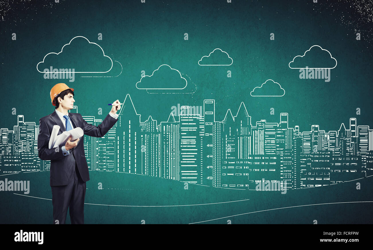 Young man engineer in helmet drawing construction project Stock Photo ...