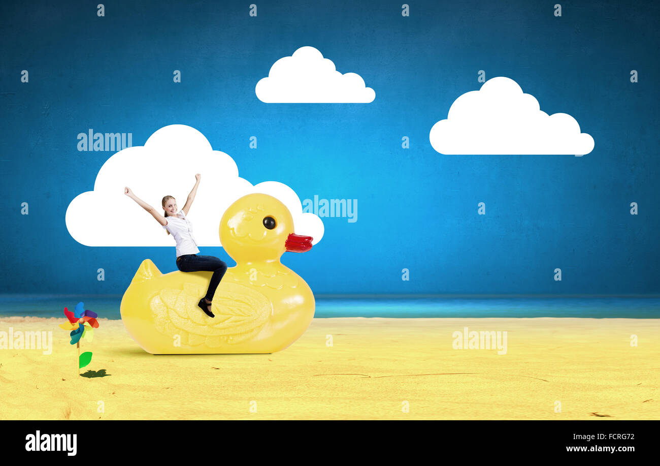 Silly young businesswoman in work break riding on plastic duck Stock ...
